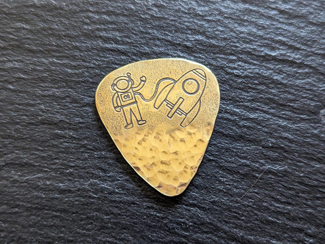 Brass Guitar Pick With Astronaut and Rocket on Front Along With a ...