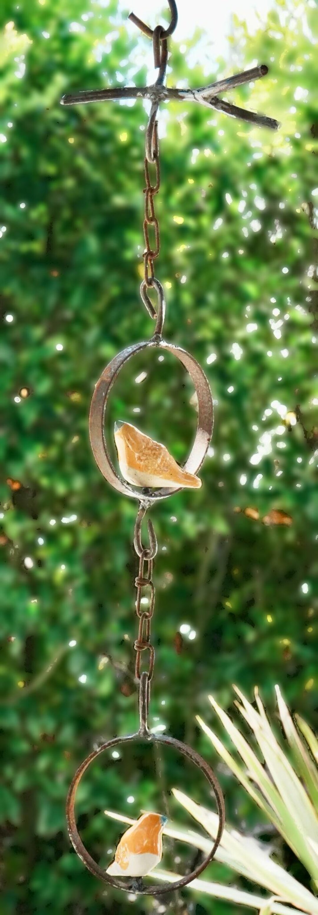 Hand Carved Ceramic Birds Hanging in Medal Hoops Below a Whimsical ...