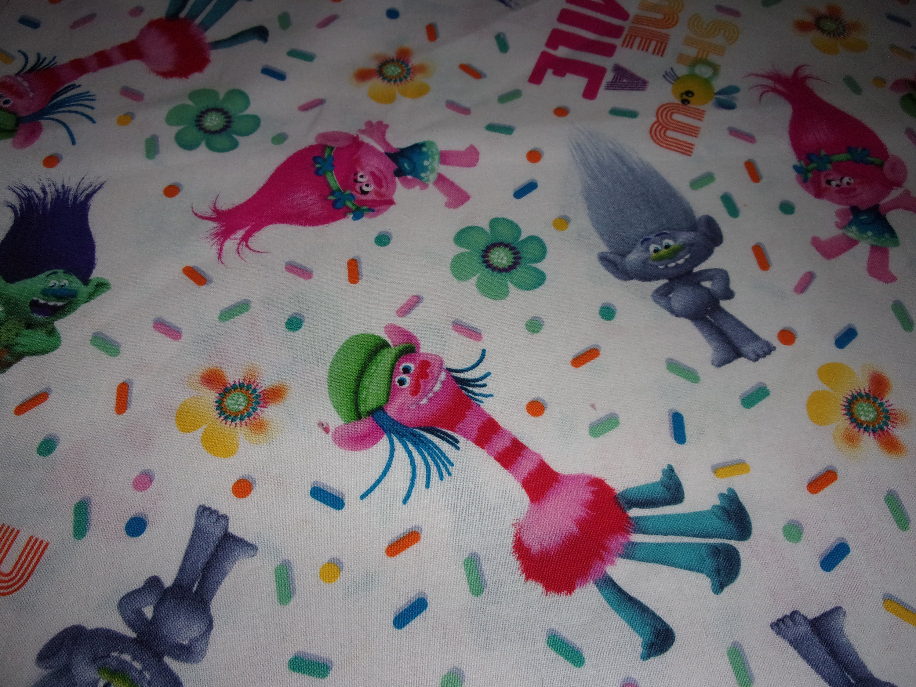 Trolls Poppy Show Me a Smile Toss White Background Fabric Sold by Yard ...