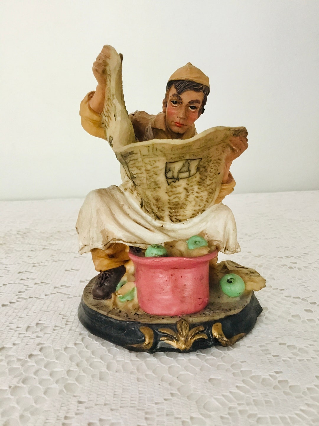 Vintage Figure Sitting on Crate Working With Apples, Reading a ...