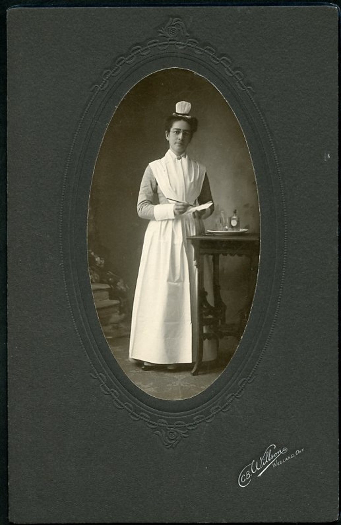 NURSE TAKING NOTES Standing Next to Medicine - C1910 Cabinet Photo by C ...