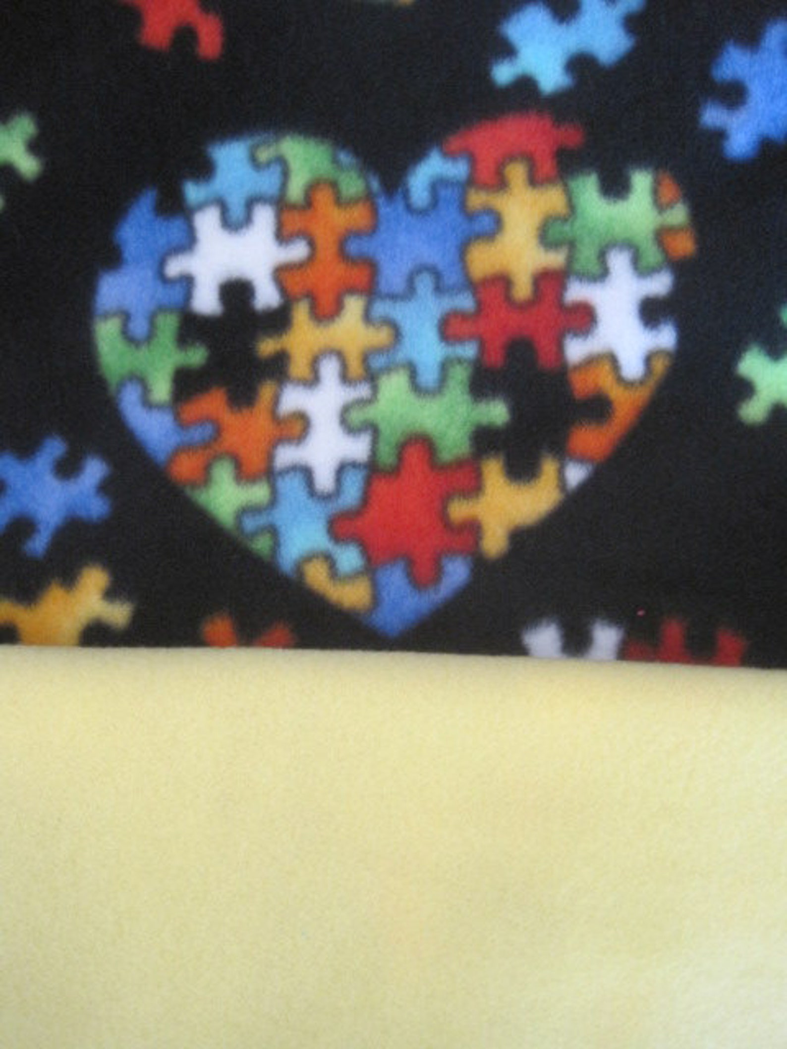 Autism Logo Puzzle Pieces in a Heart With Yellow Handmade Blanket ...