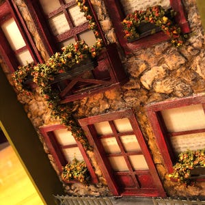 Charming Miniature Stone House With Red Accents and Flower Details ...