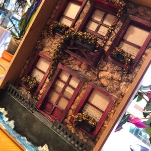 Charming Miniature Stone House With Red Accents and Flower Details ...