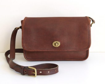 brown coach purse with red trim