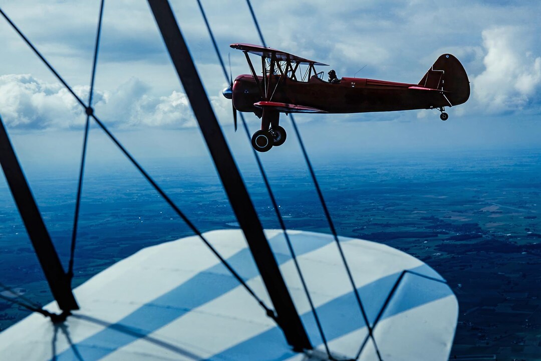 Classic Biplanes Soaring Above Country Landscape. in Formation Flight ...