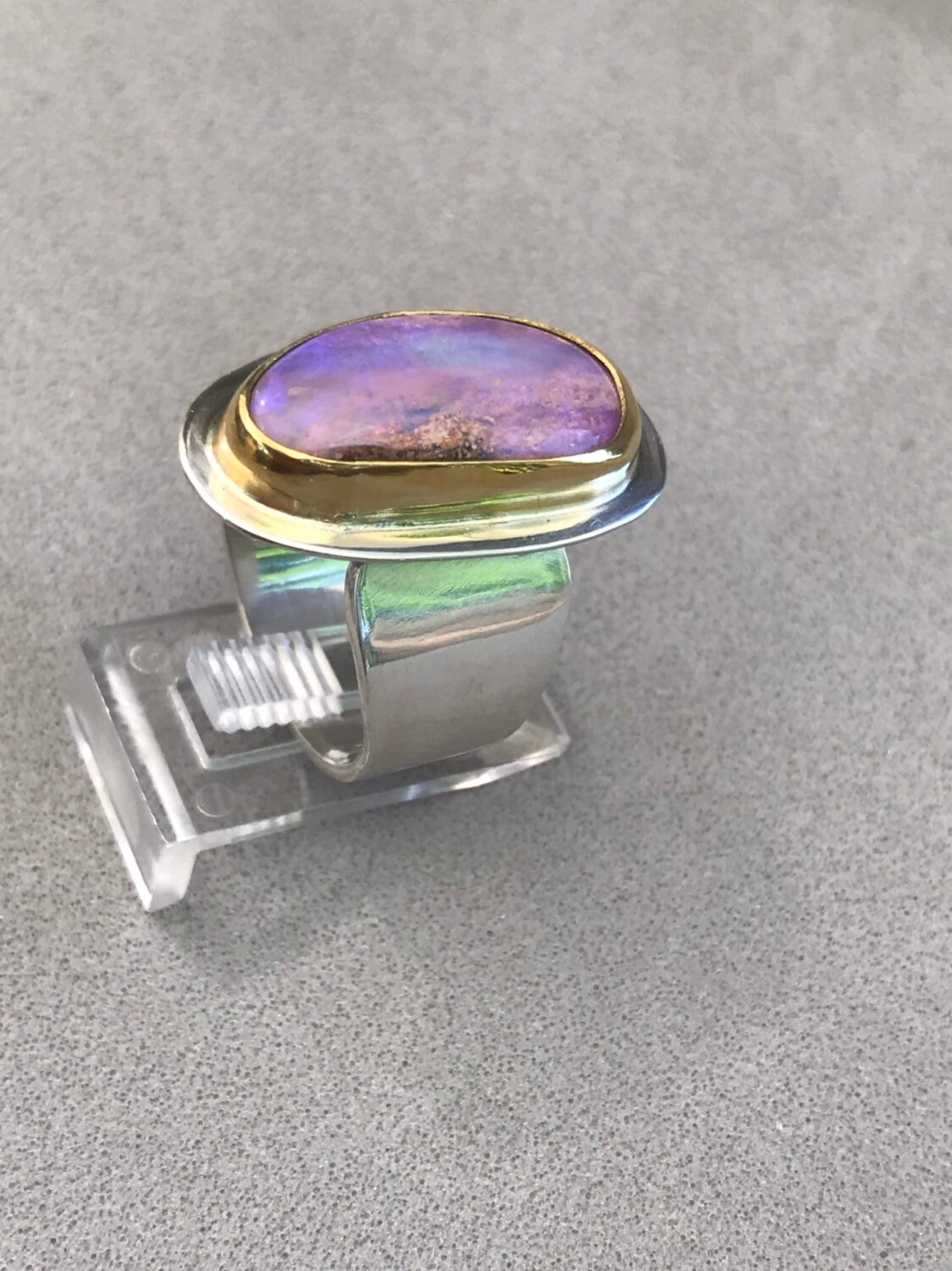 Pipe crystal opal ring in a gold bezel on a wide band of silver