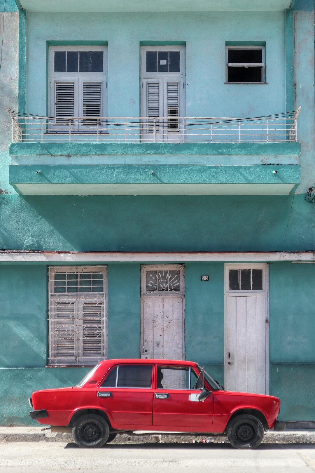Red Cuban Lada Parked Under a Cuban Apartment Building in Havana ...