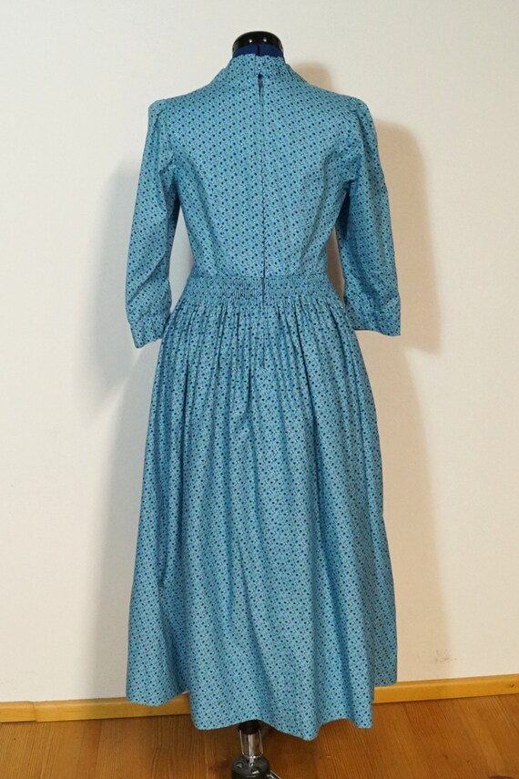 Traditional dress in light blue floral fabric, half-l… - Gem