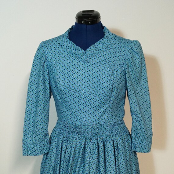 Traditional dress in light blue floral fabric, half-l… - Gem