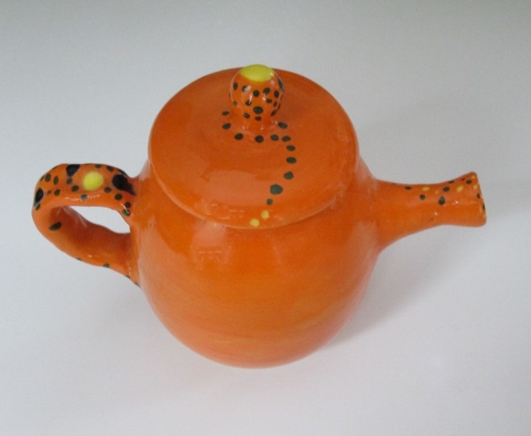 Tetera naranja tirada y decorada con ruedas aproximadamente 5 3/4 H X 7 ...