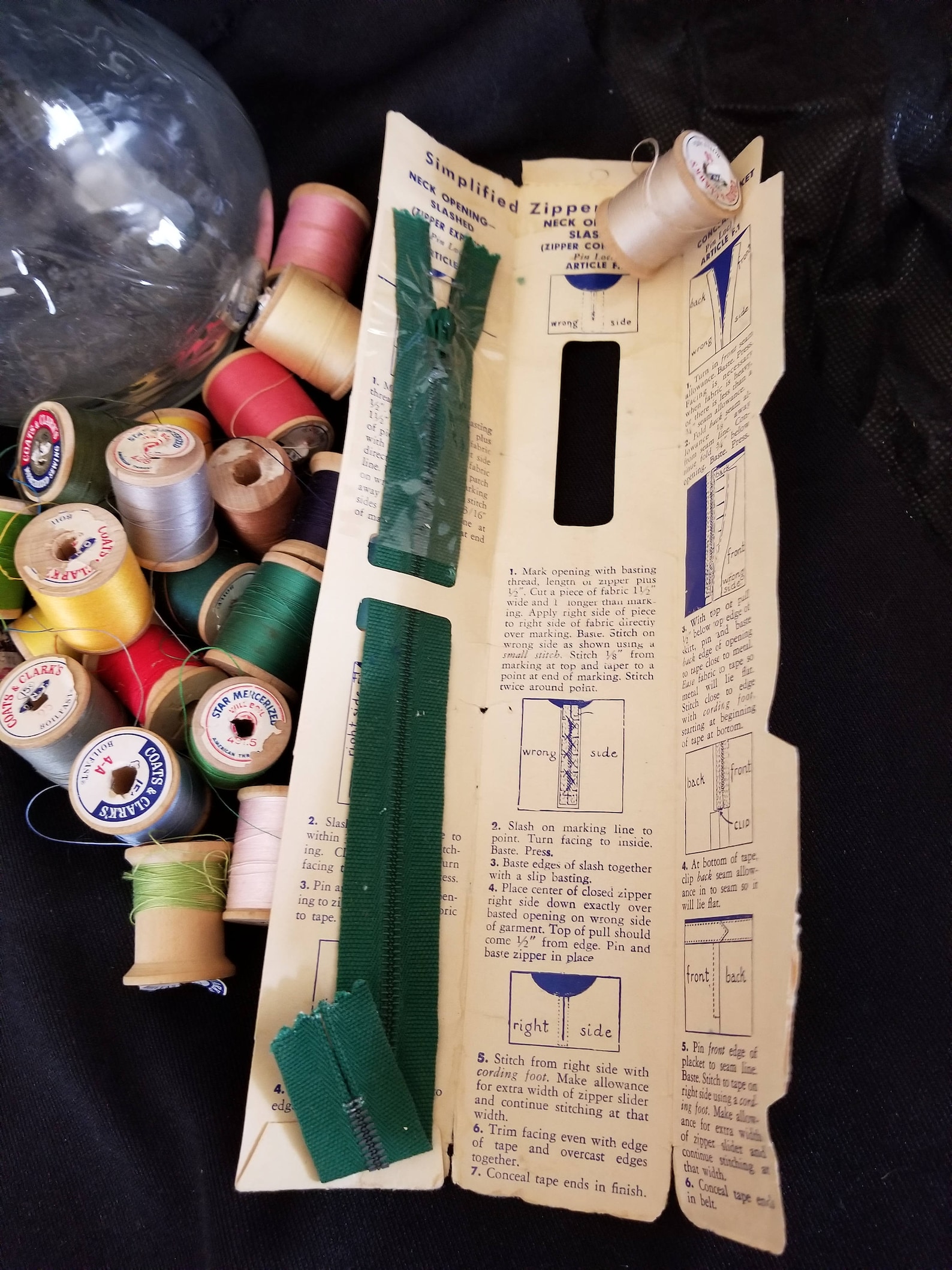 Crown Zipper and Wood Thread Spools in a Glass Pitcher With an Embossed ...