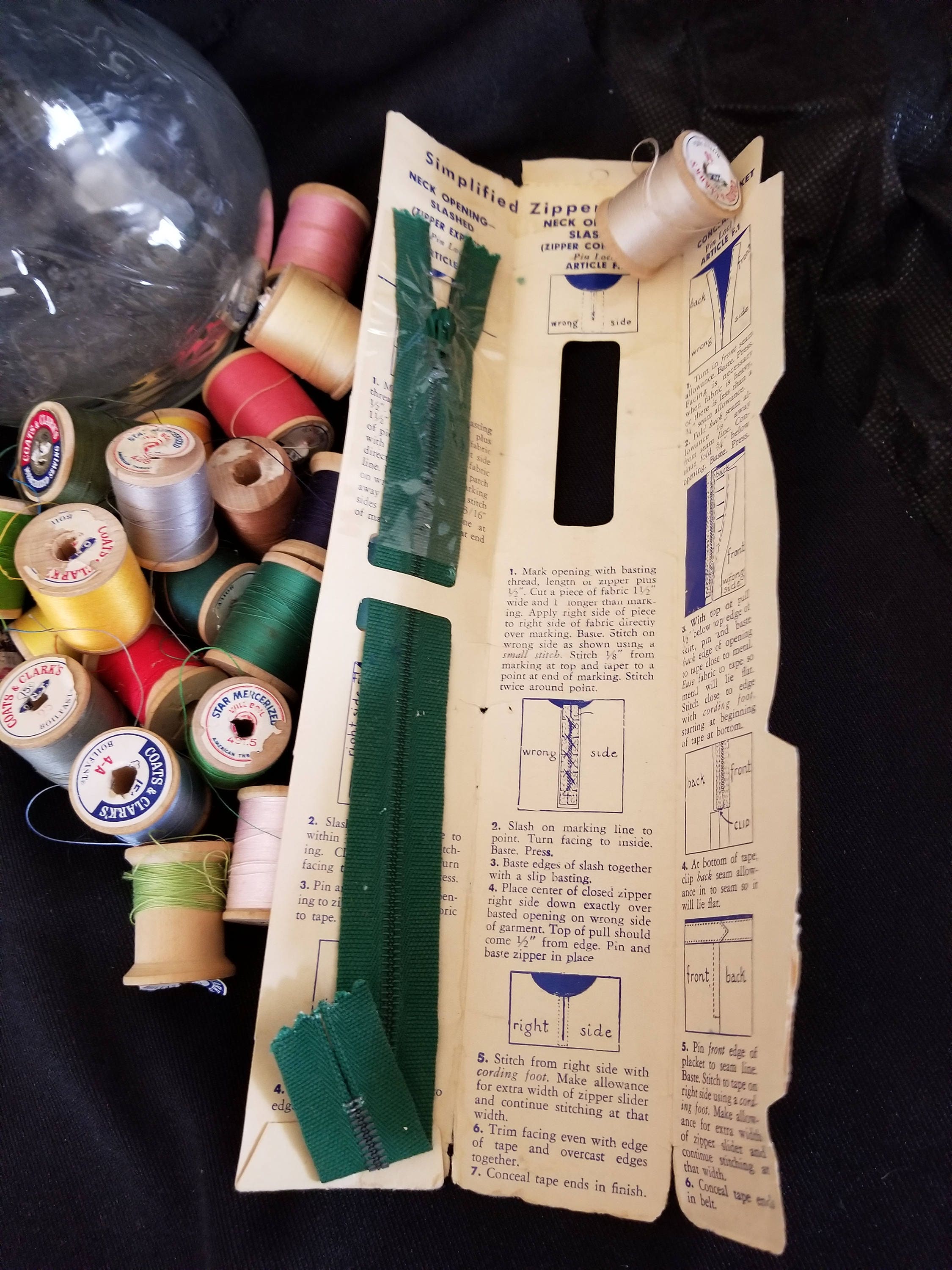 Crown Zipper and Wood Thread Spools in a Glass Pitcher With an Embossed ...