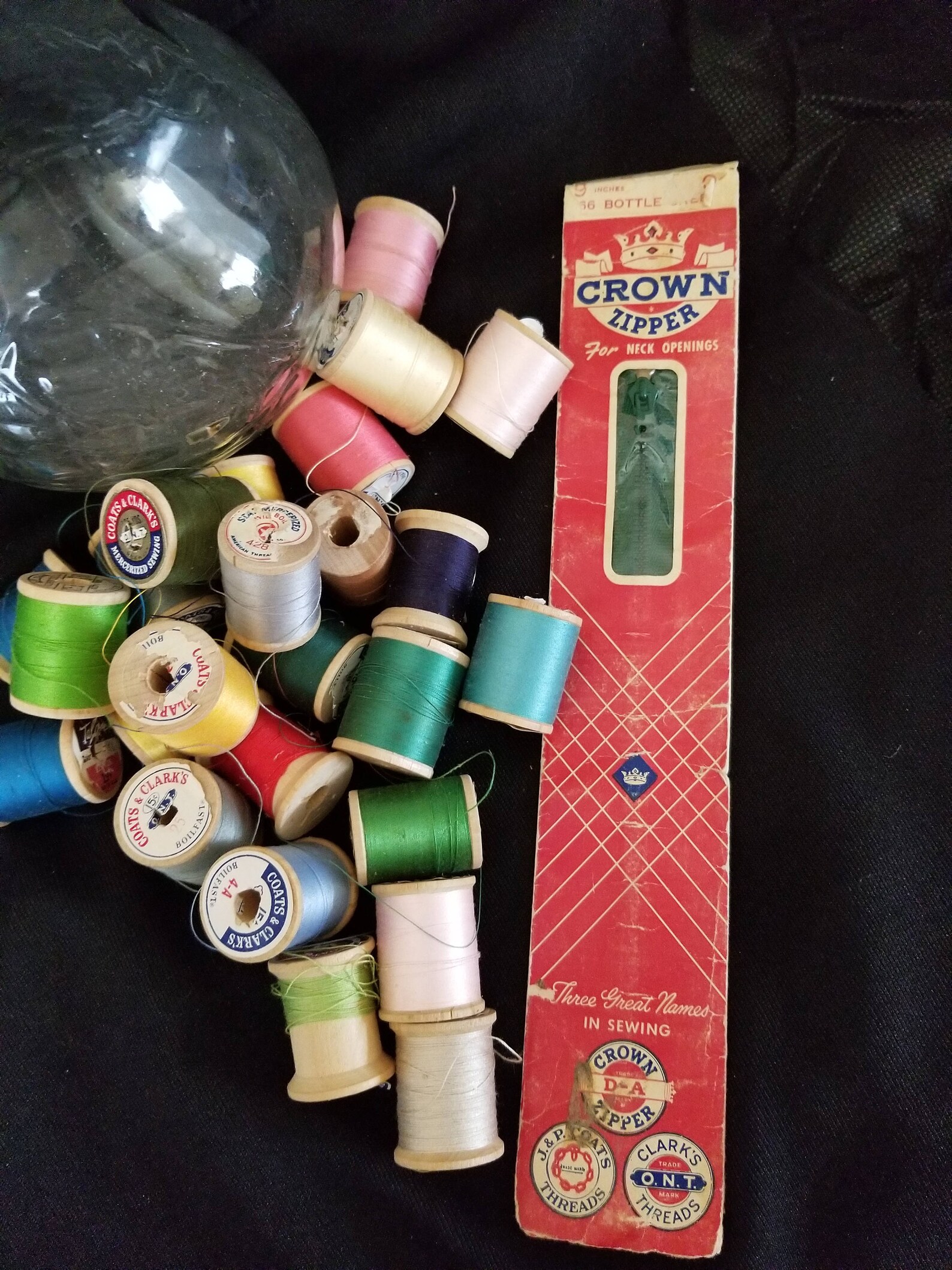 Crown Zipper and Wood Thread Spools in a Glass Pitcher With an Embossed ...