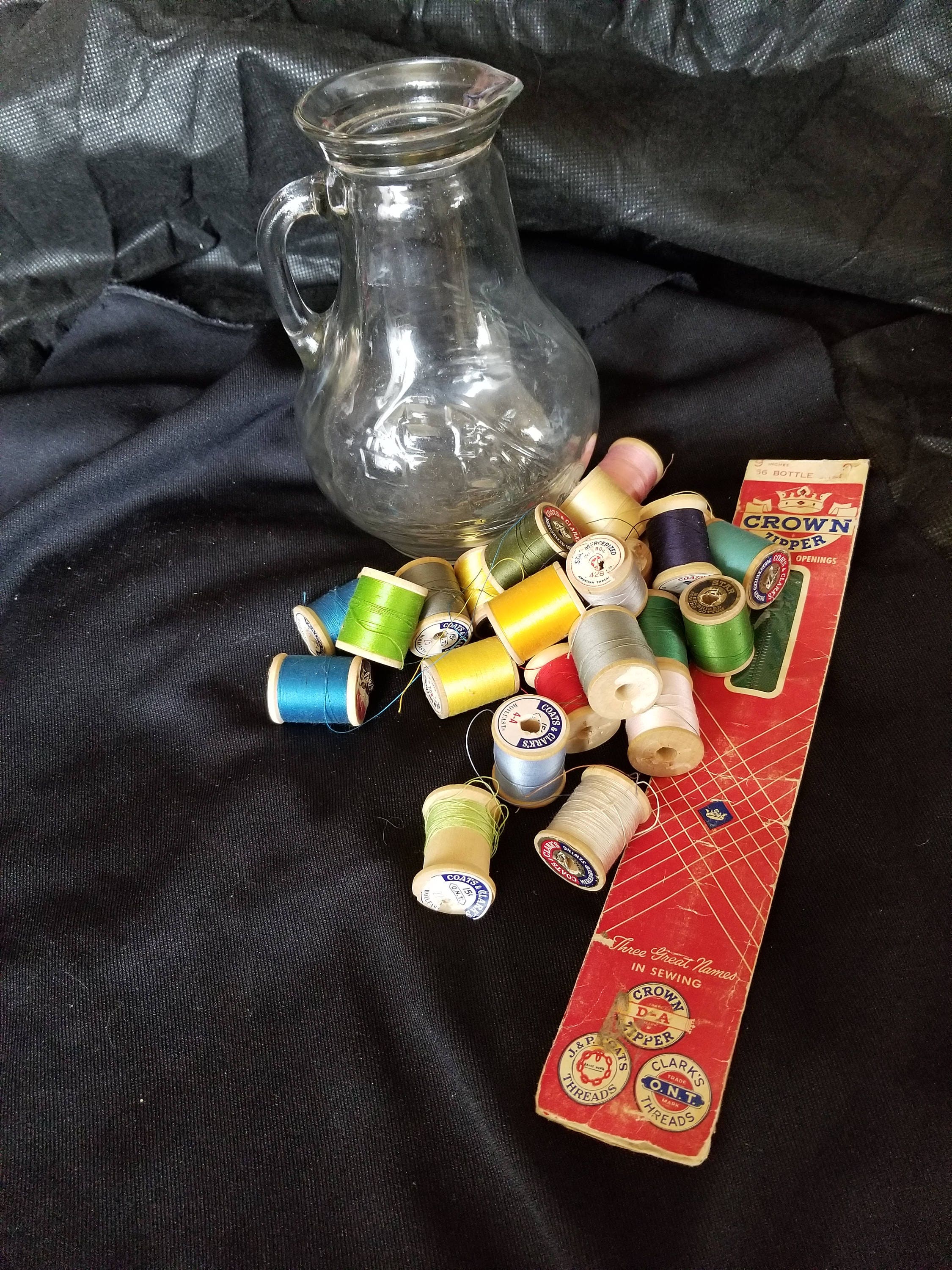 Crown Zipper and Wood Thread Spools in a Glass Pitcher With an Embossed ...