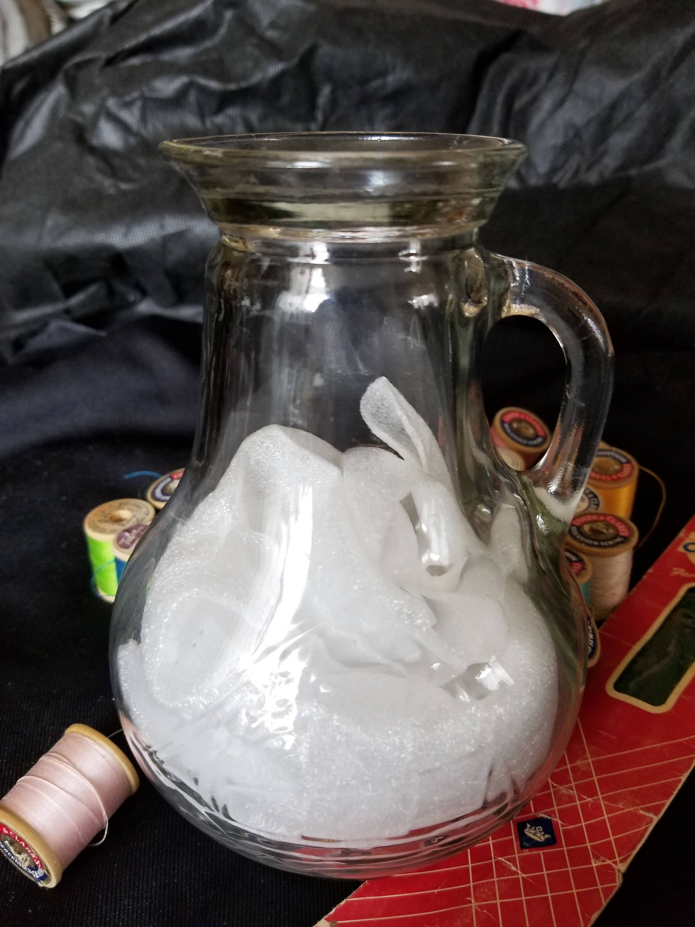 Crown Zipper and Wood Thread Spools in a Glass Pitcher With an Embossed ...