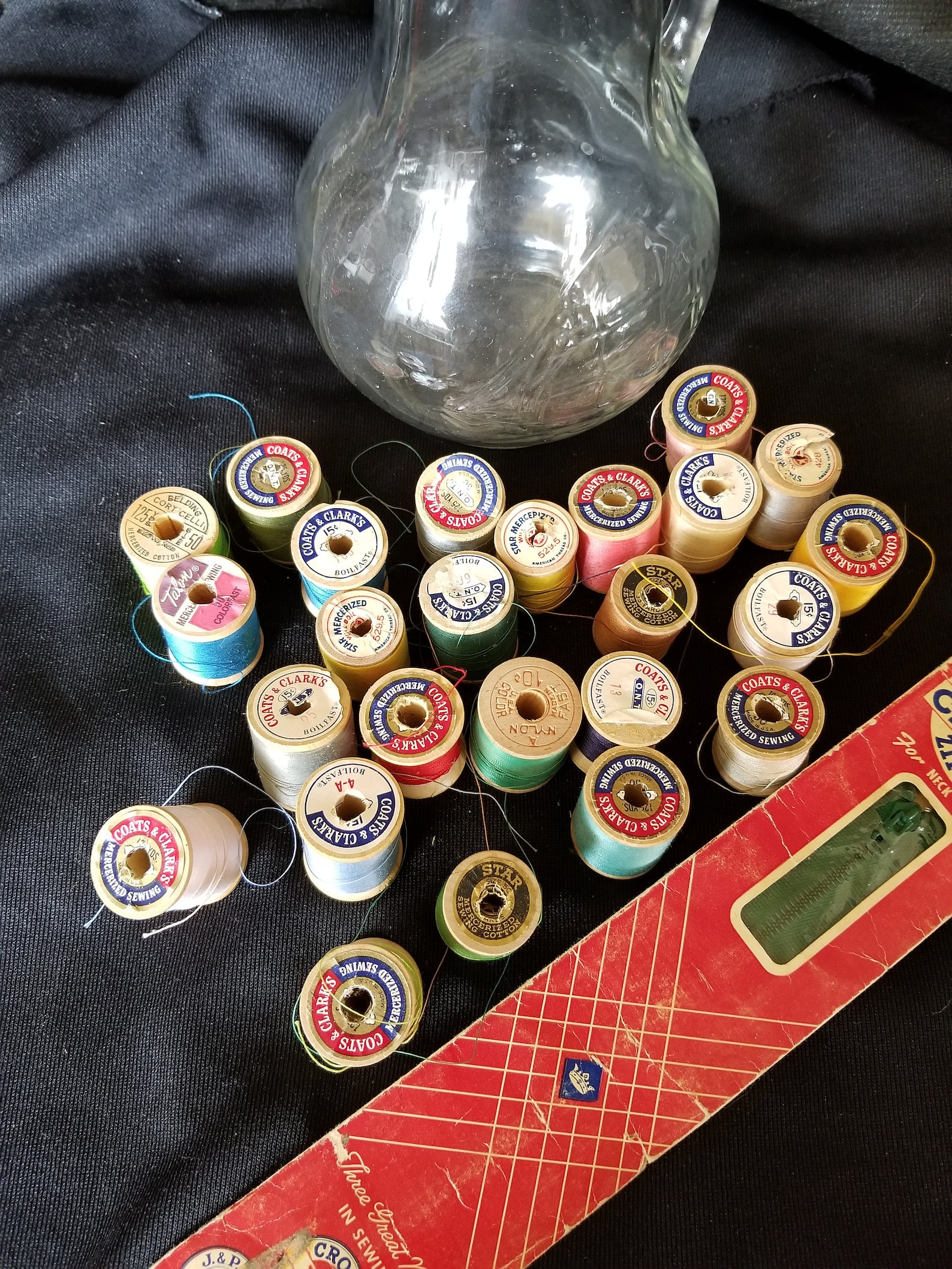 Crown Zipper and Wood Thread Spools in a Glass Pitcher With an Embossed ...