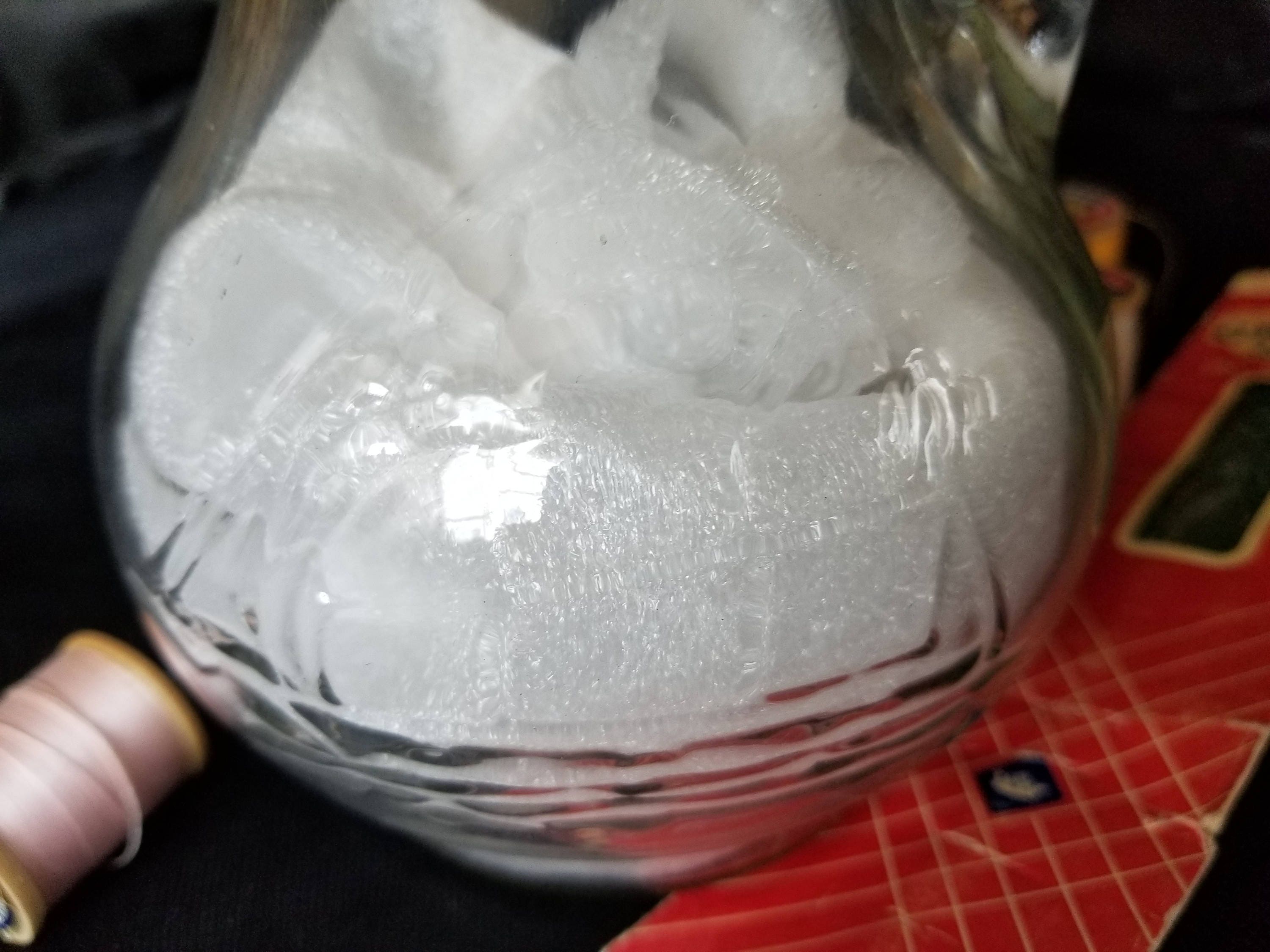 Crown Zipper and Wood Thread Spools in a Glass Pitcher With an Embossed ...