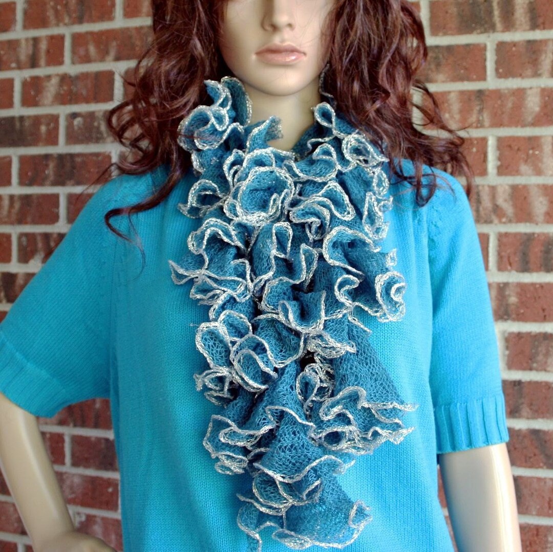 Esta hermosa bufanda con volantes turquesa tiene un borde plateado que ...