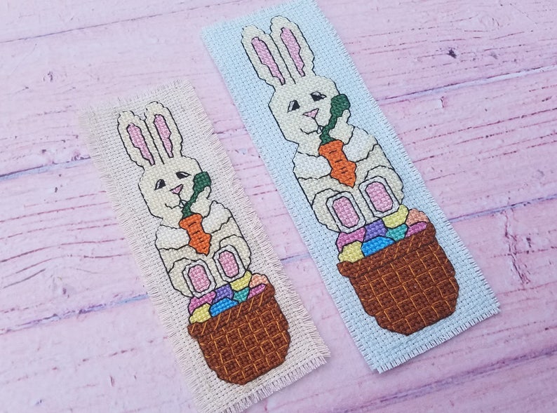 Bunny Sitting on a Basket of Easter Eggs and Holding a Carrot Cross ...