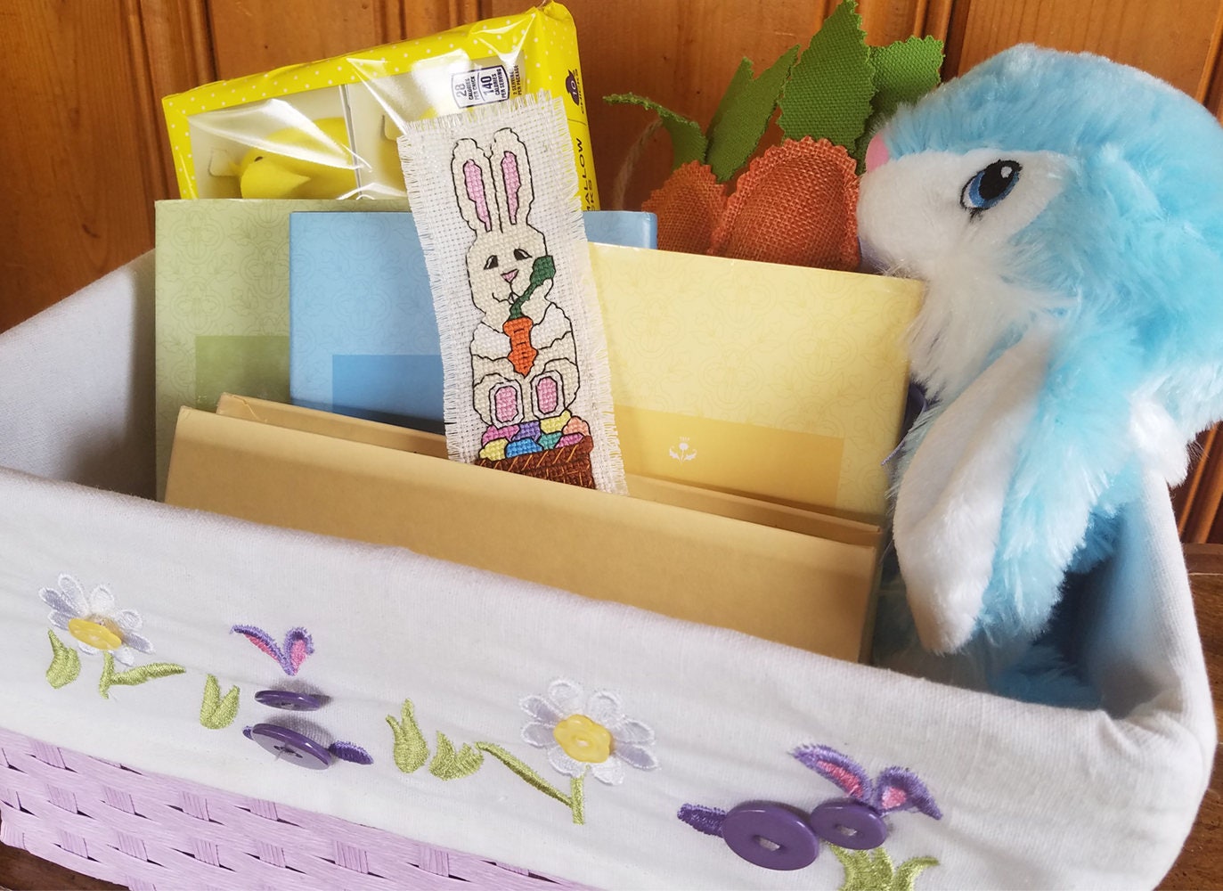 Bunny Sitting on a Basket of Easter Eggs and Holding a Carrot Cross ...