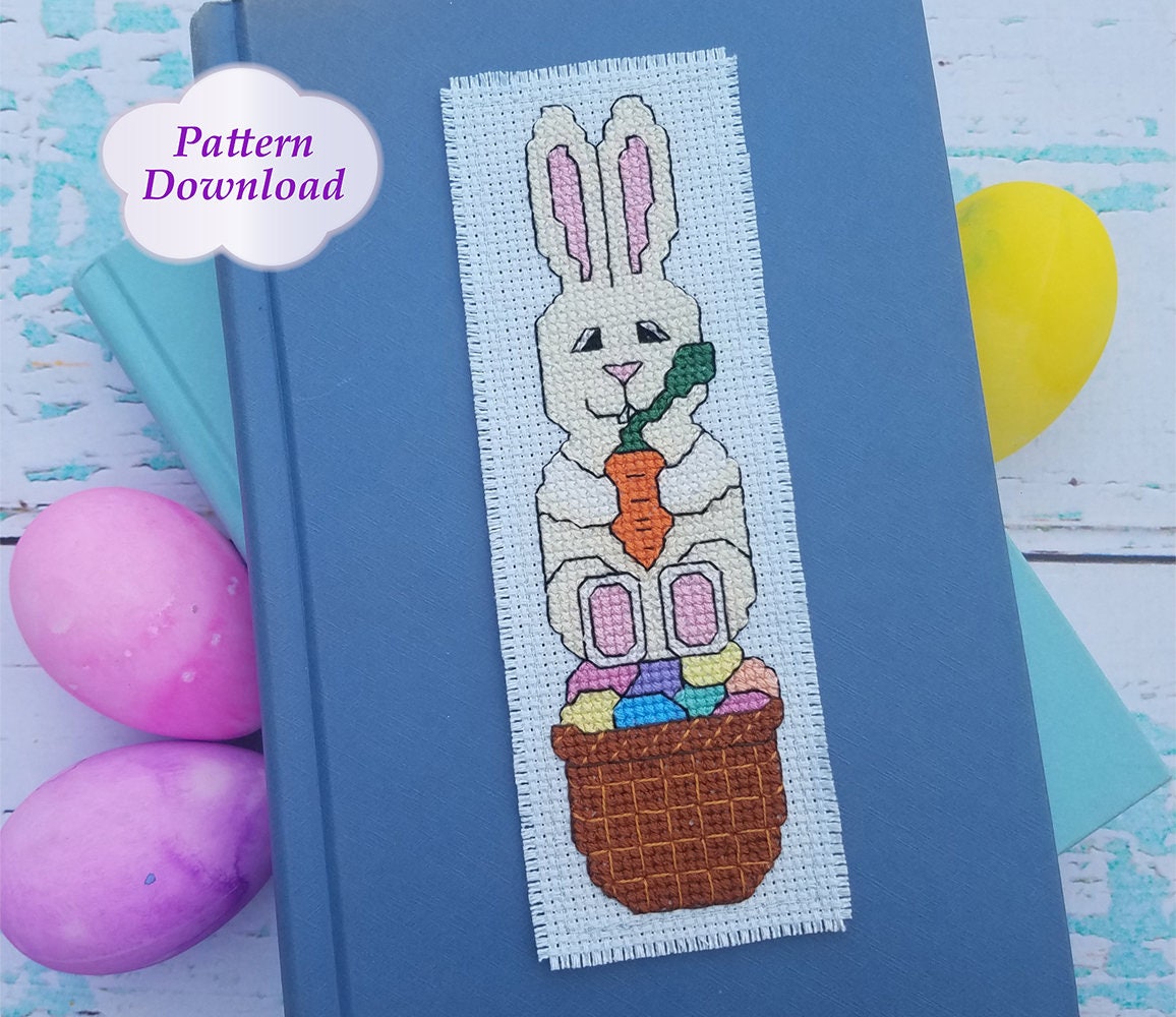 Bunny Sitting on a Basket of Easter Eggs and Holding a Carrot Cross ...