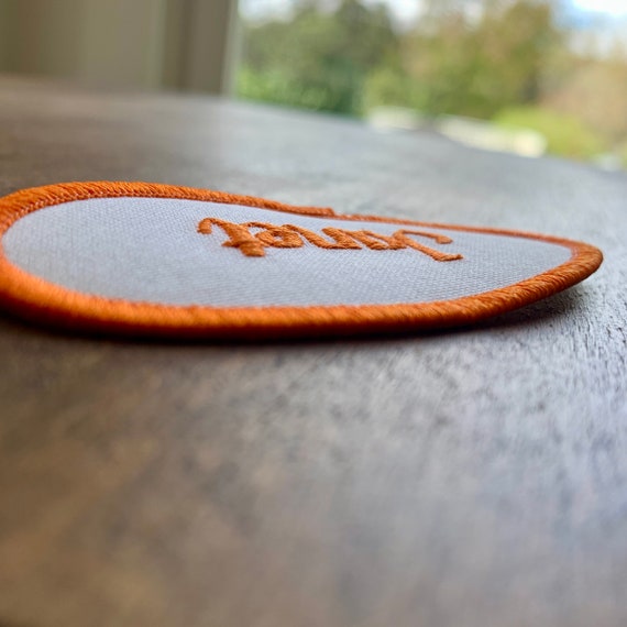 Janet. A white work shirt patch that says "Janet" in … - Gem