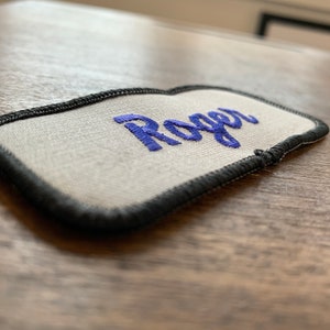 Roger. A White Work Shirt Name Patch That Says "roger" in Blue Script ...