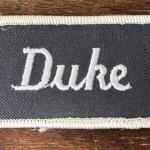 Duke. A Gray Patch That Says "duke" in White Script With White Border ...