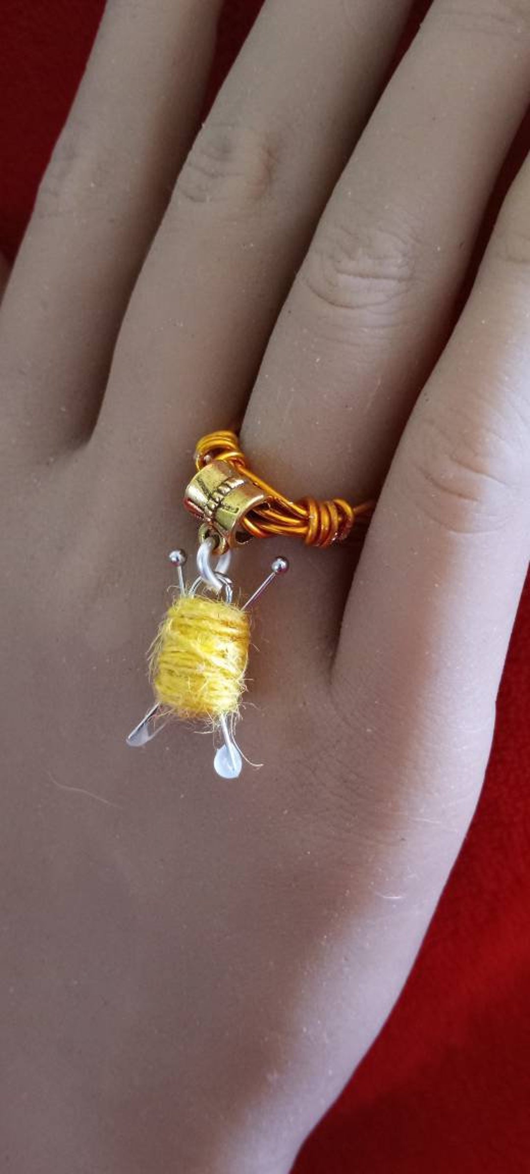 Gold Wire Holding a Quirky Bolt of Yarn Charm Ring With Knitting ...