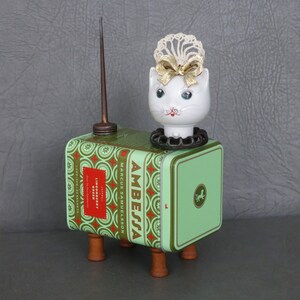 Assemblage Cat. ambessa. Porcelain Cat Head, Tea Tin, Wooden Spools ...