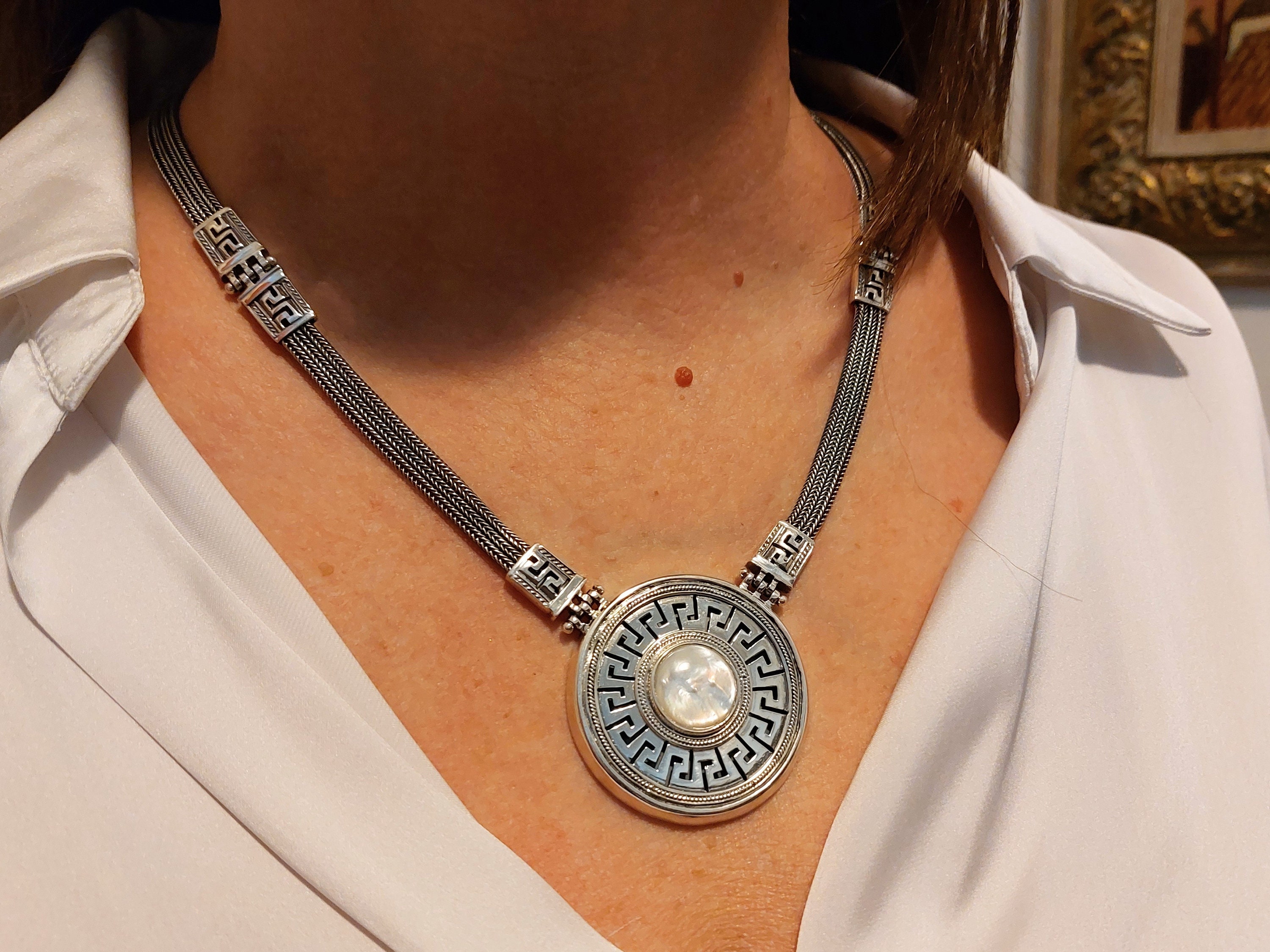 Ethnic style necklace with Greek key motif and mother of pearl inlay.