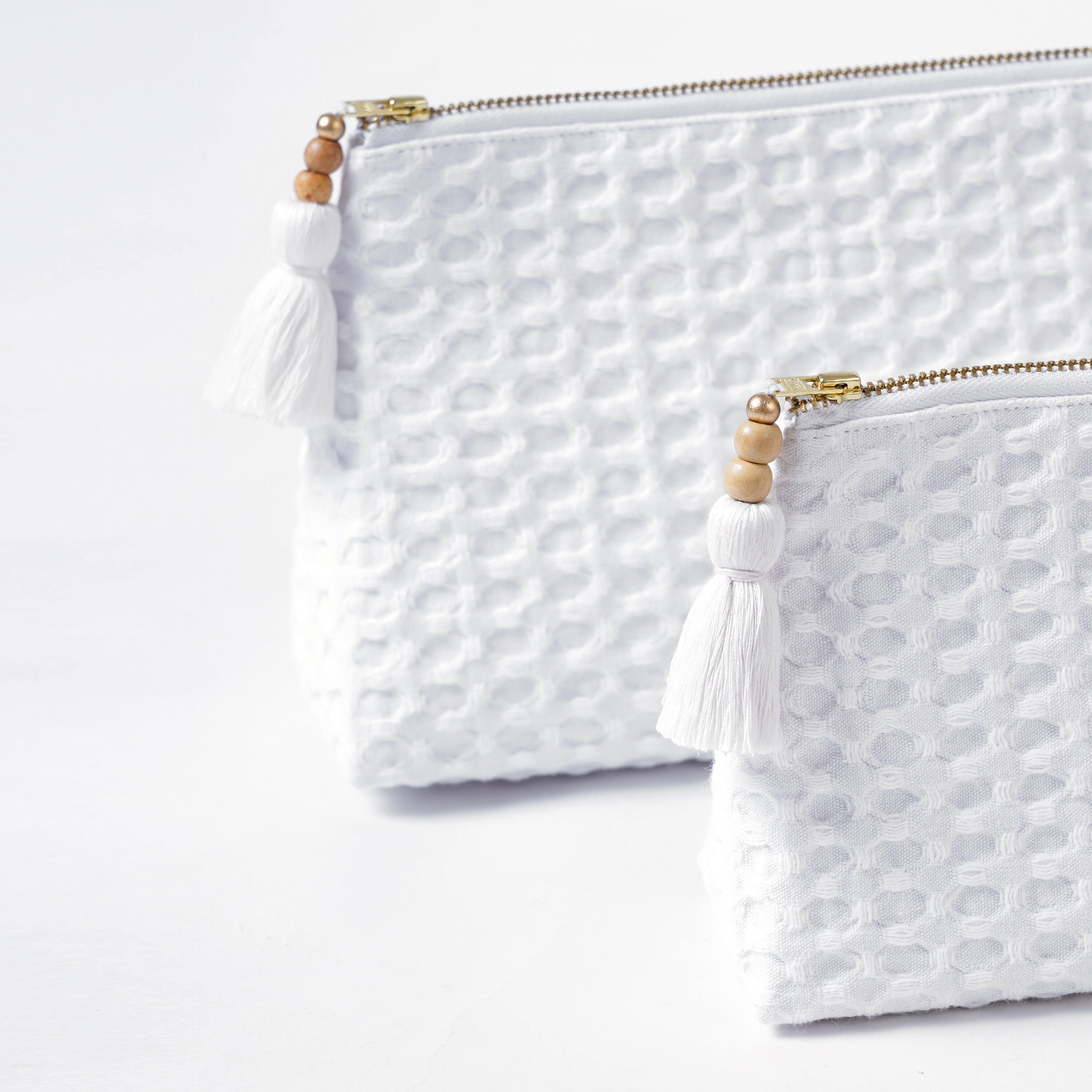 A Pair of White Waffle Nesting Pouches With Zipper Closure and Tassel ...