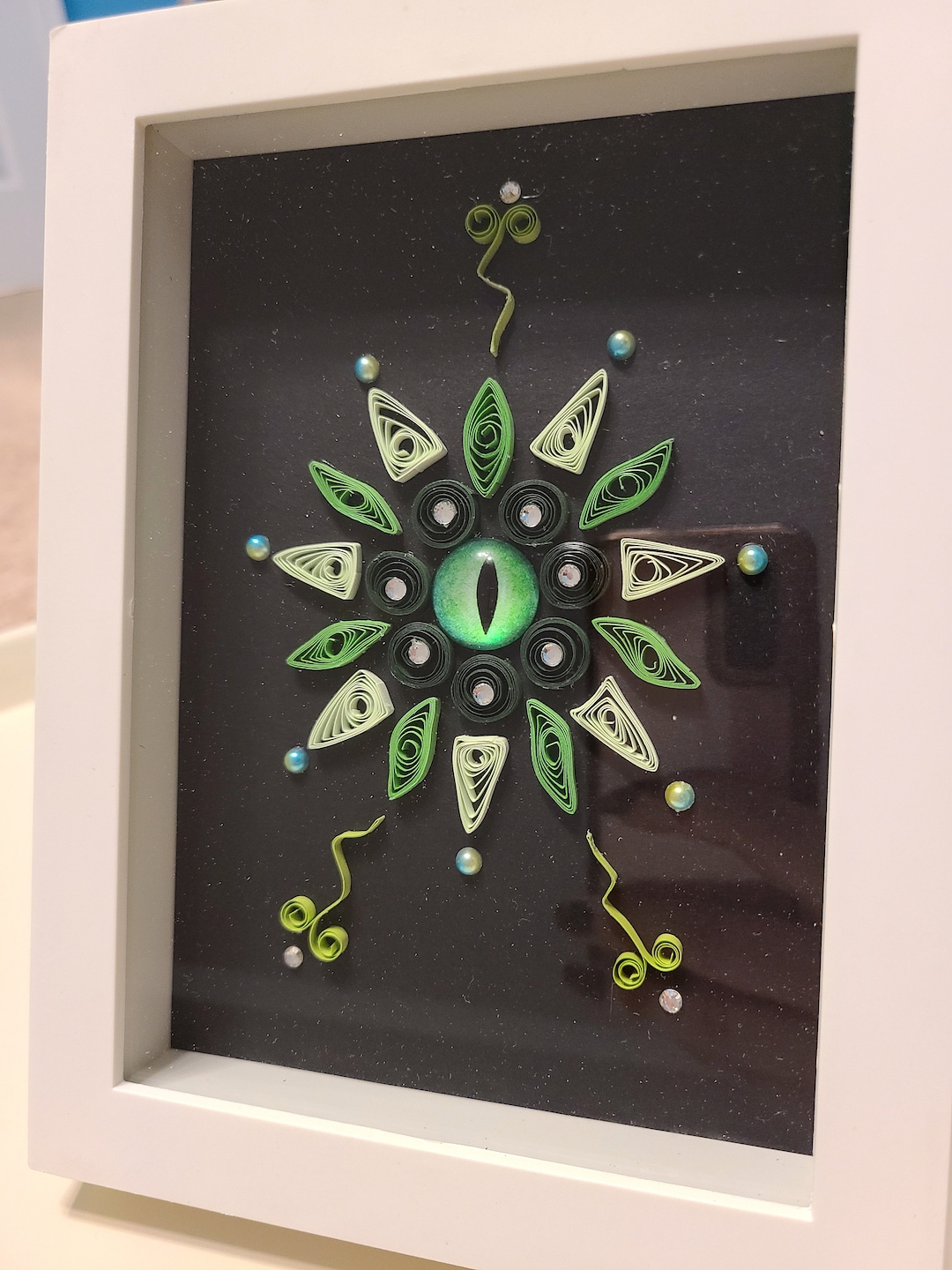 Quilling Art With Green Accents and Rhinestones Around a Glass Eye in ...
