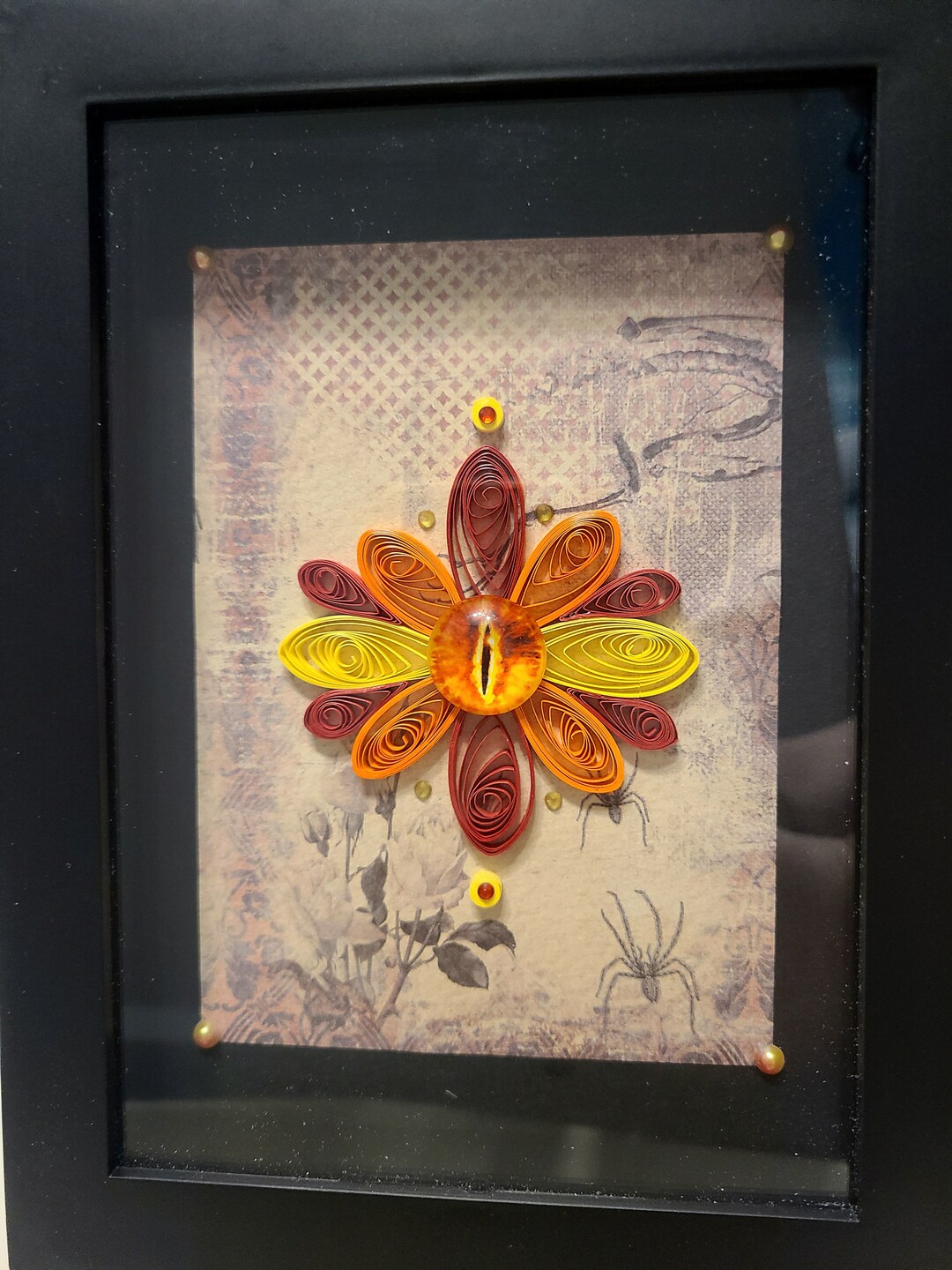 Quilling Art With Red, Orange, and Yellow Accents Around a Glass Eye in ...