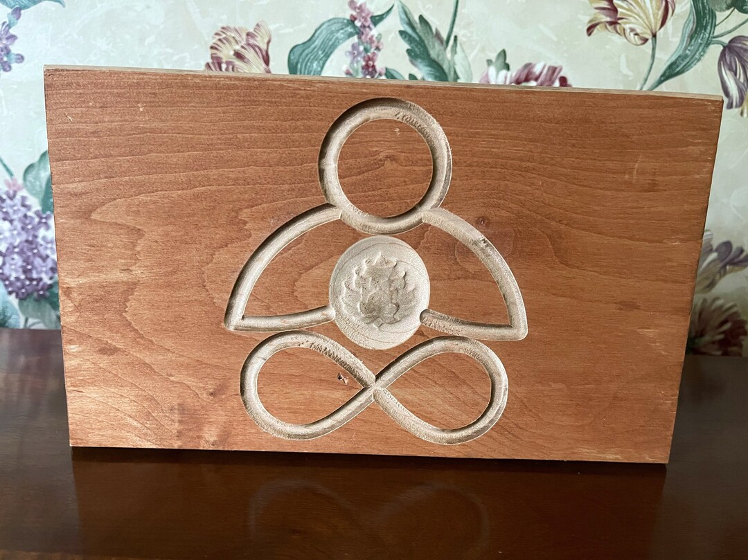 Meditating Figure With Infinity Symbol Legs and Lotus Carving at Heart ...