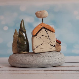 Small Sculpture Art of a Ceramic Houses and Trees on a Flat Gray Beach ...