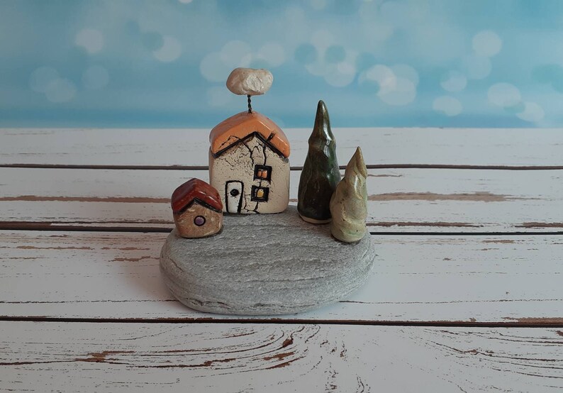 Small Sculpture Art of a Ceramic Houses and Trees on a Flat Gray Beach ...
