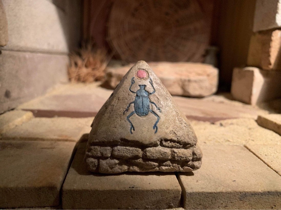 Egyptian pyramid featuring the eye of Horus, Ankh, Djed pillar, and Scarab