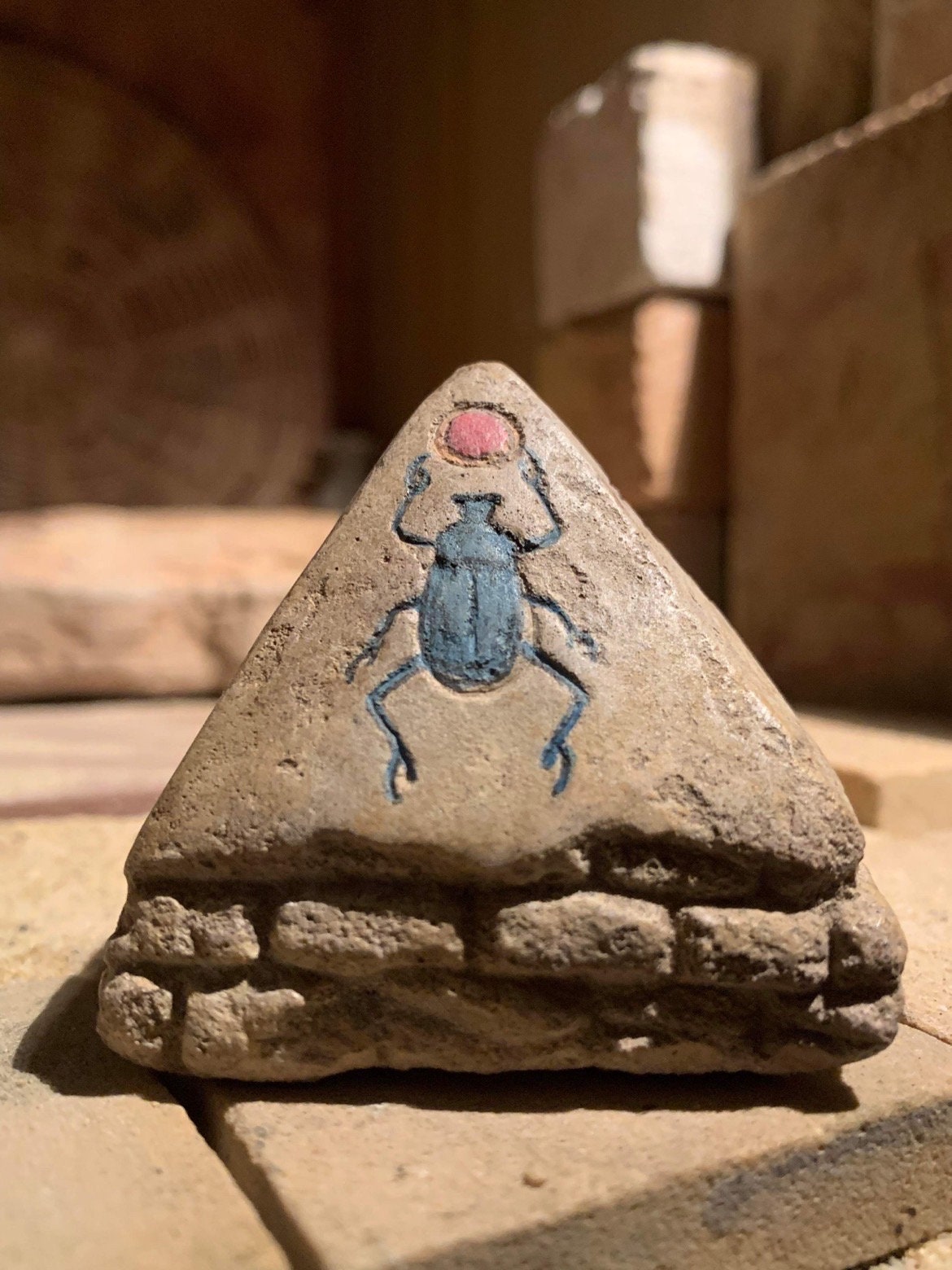 Egyptian pyramid featuring the eye of Horus, Ankh, Djed pillar, and Scarab