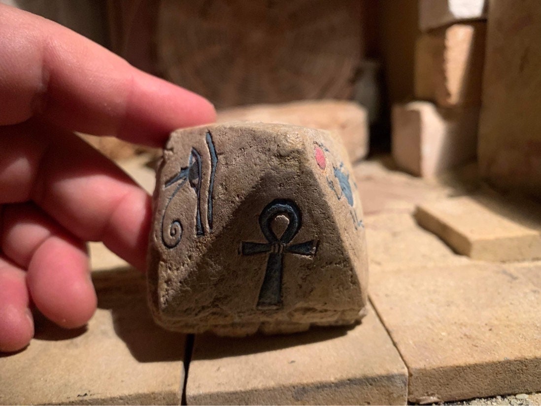 Egyptian pyramid featuring the eye of Horus, Ankh, Djed pillar, and Scarab