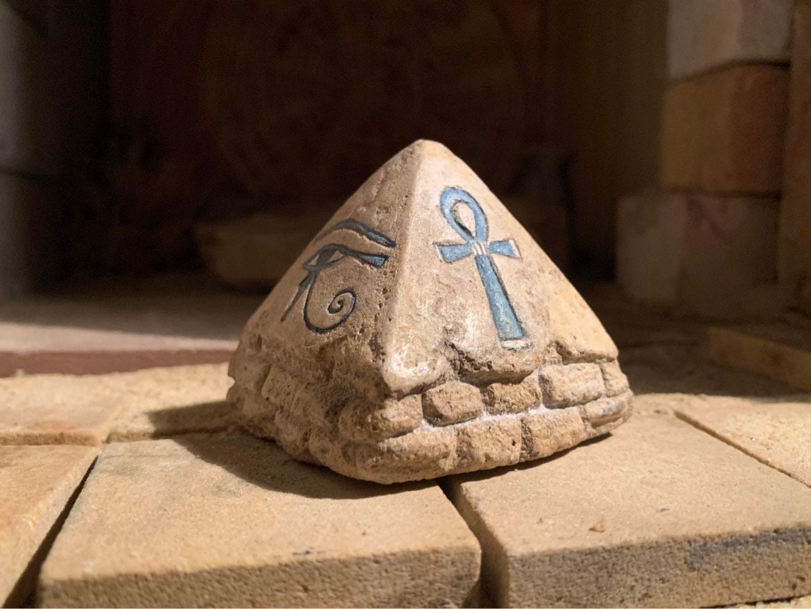 Egyptian pyramid featuring the eye of Horus, Ankh, Djed pillar, and Scarab