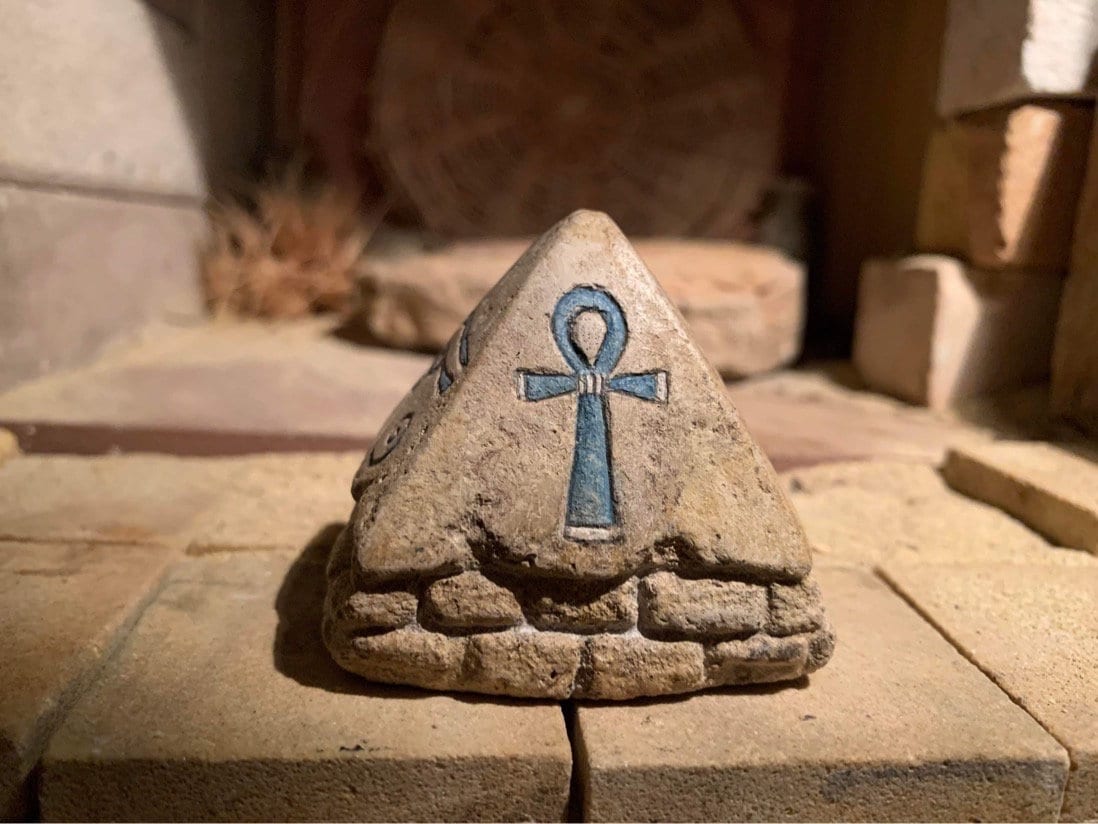 Egyptian pyramid featuring the eye of Horus, Ankh, Djed pillar, and Scarab