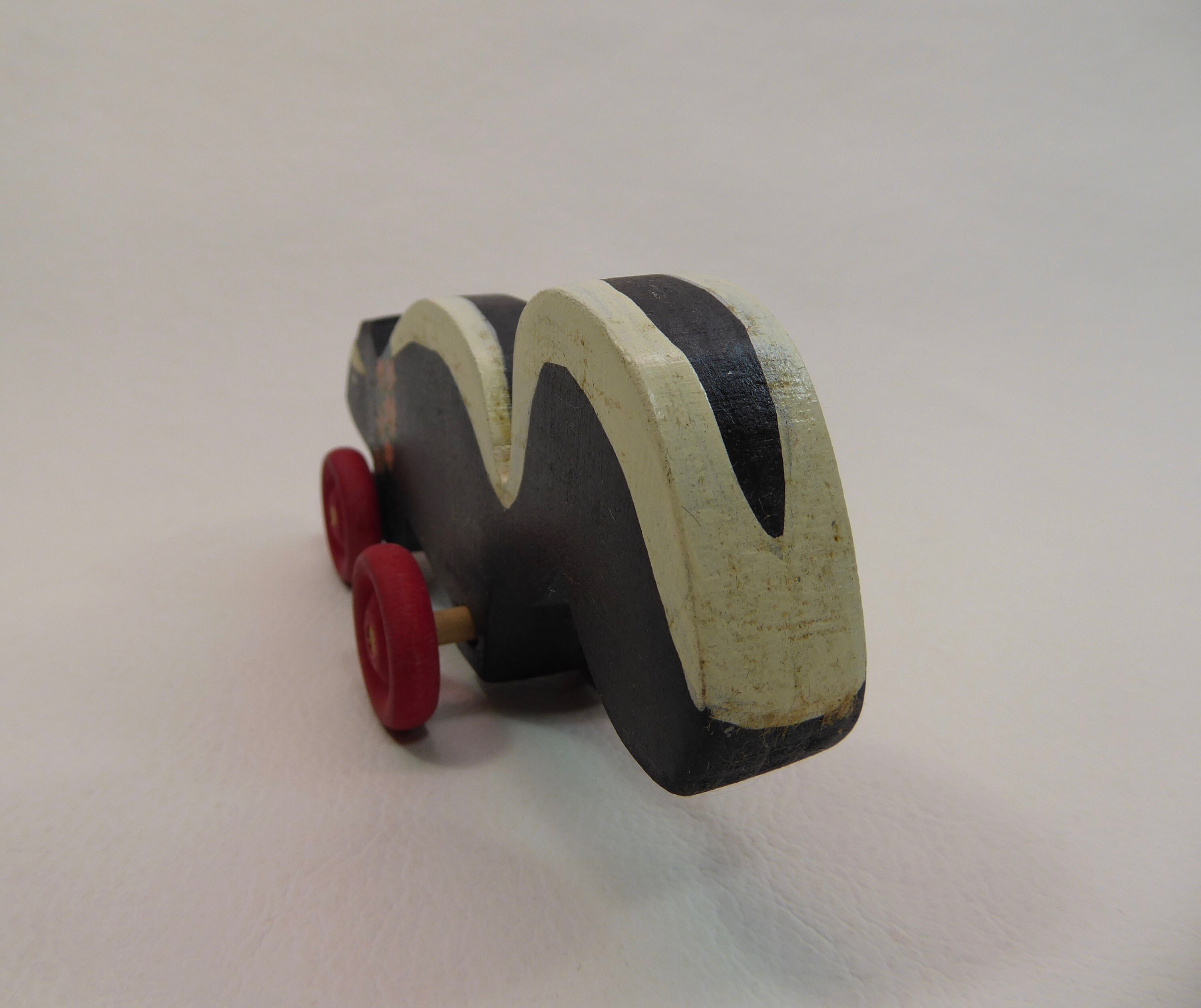 Skunk figurine. Skunk. Toy on wheels. Vintage wood carving. 1960's ...