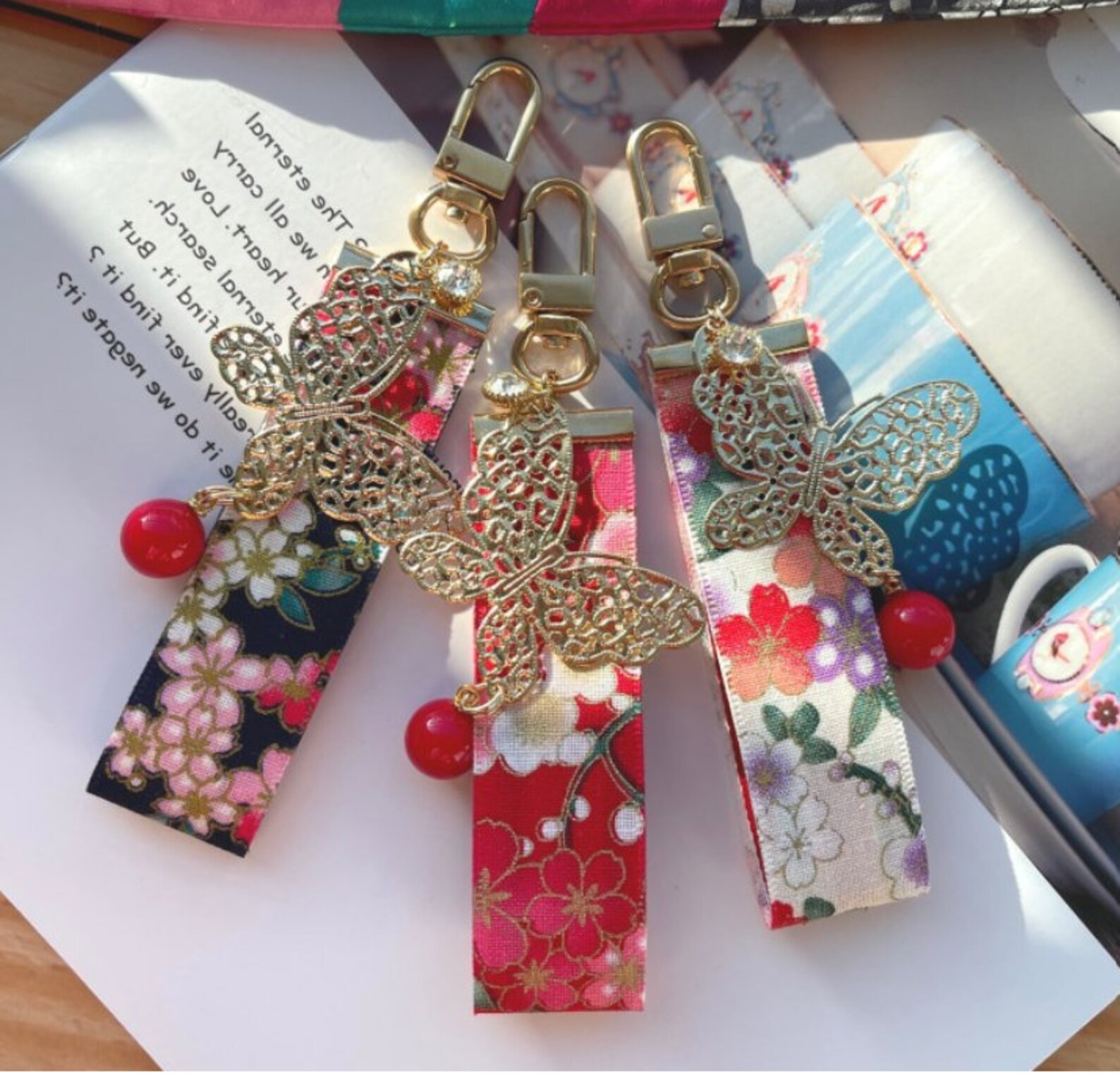 Three Oriental Colorful Butterfly Keyrings on Flower Pattern Fabric ...