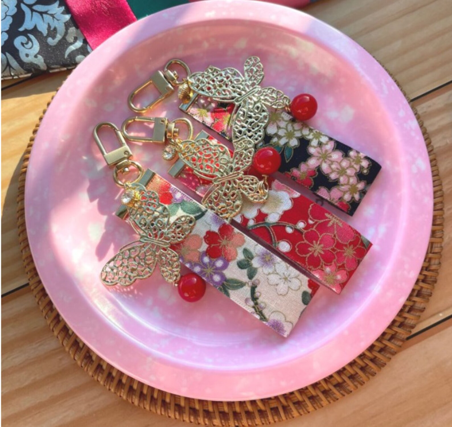 Three Oriental Colorful Butterfly Keyrings on Flower Pattern Fabric ...
