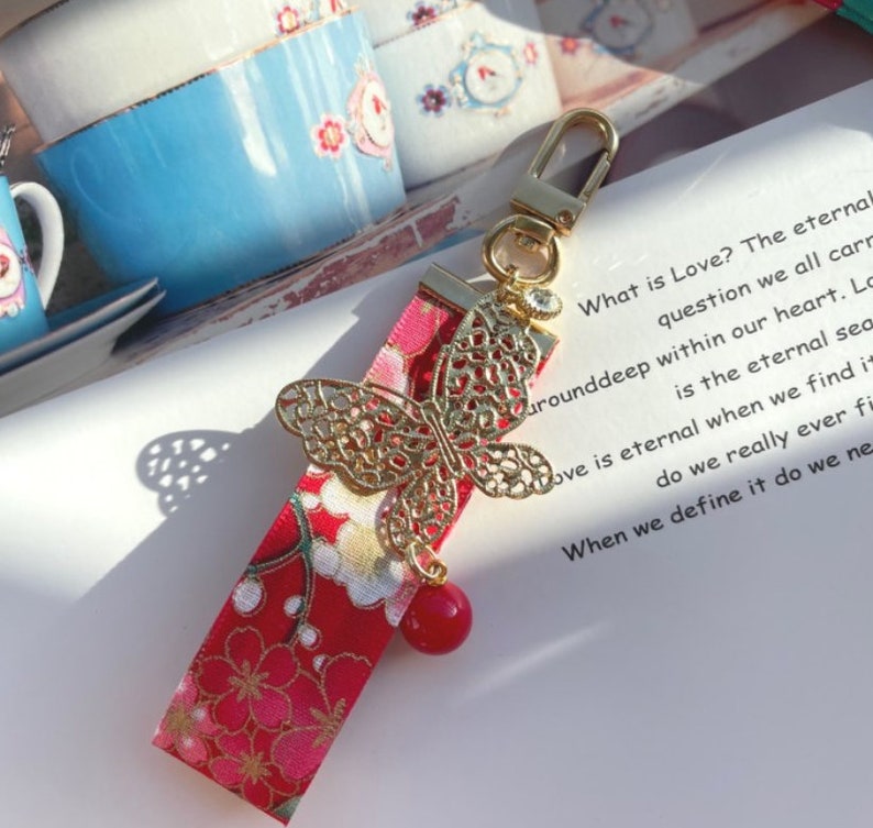 Three Oriental Colorful Butterfly Keyrings on Flower Pattern Fabric ...