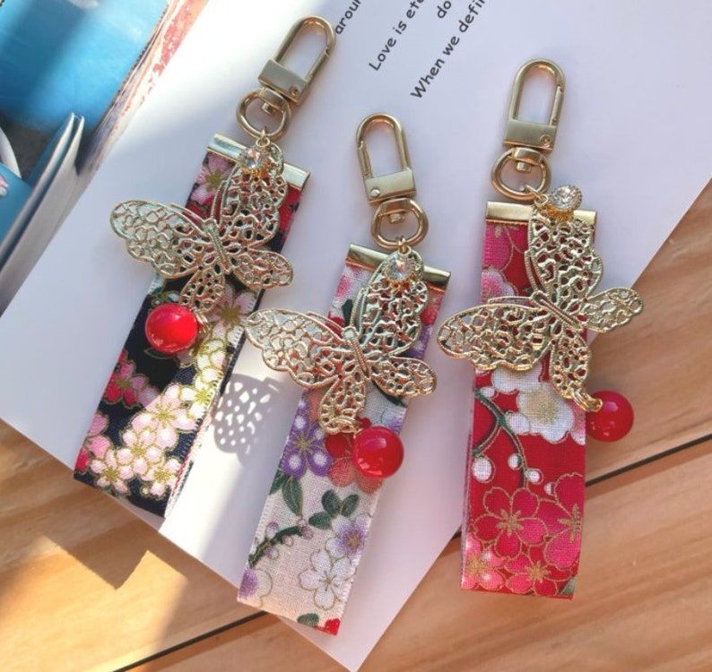 Three Oriental Colorful Butterfly Keyrings on Flower Pattern Fabric ...