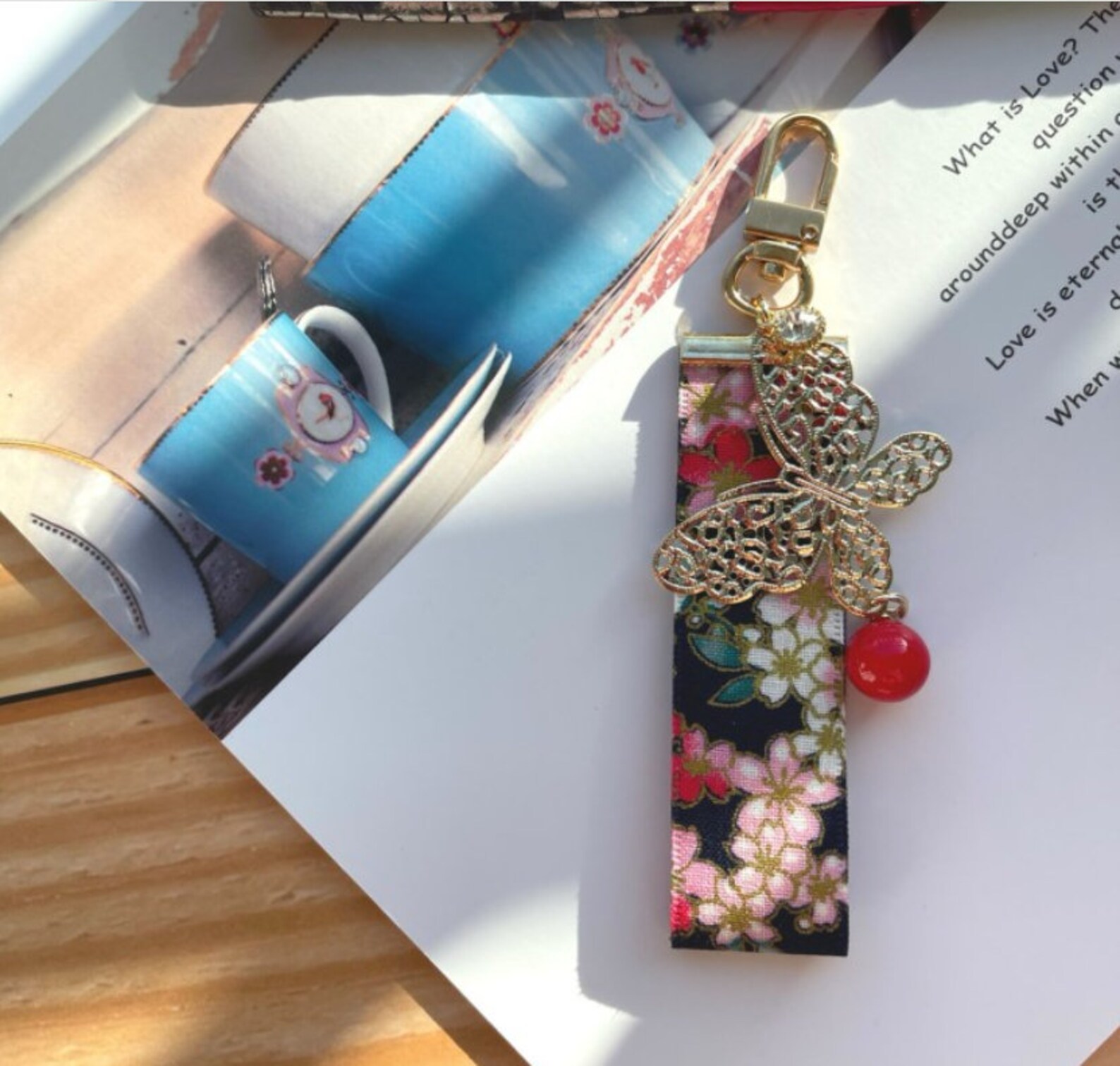 Three Oriental Colorful Butterfly Keyrings on Flower Pattern Fabric ...