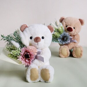 Teddy bear holding flowers store